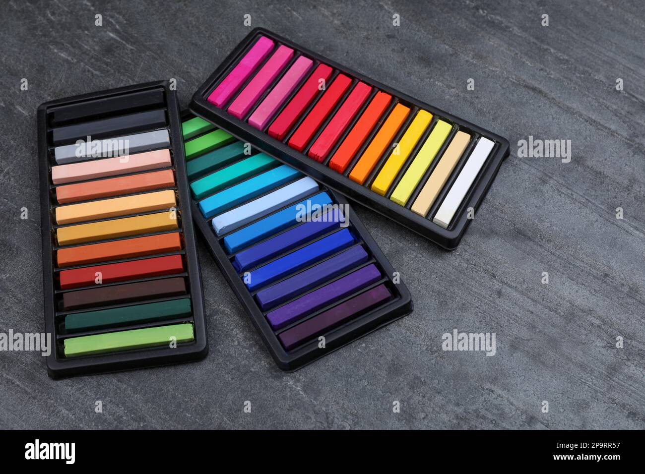 Colorful pastels in trays on grey stone table. Drawing materials Stock ...