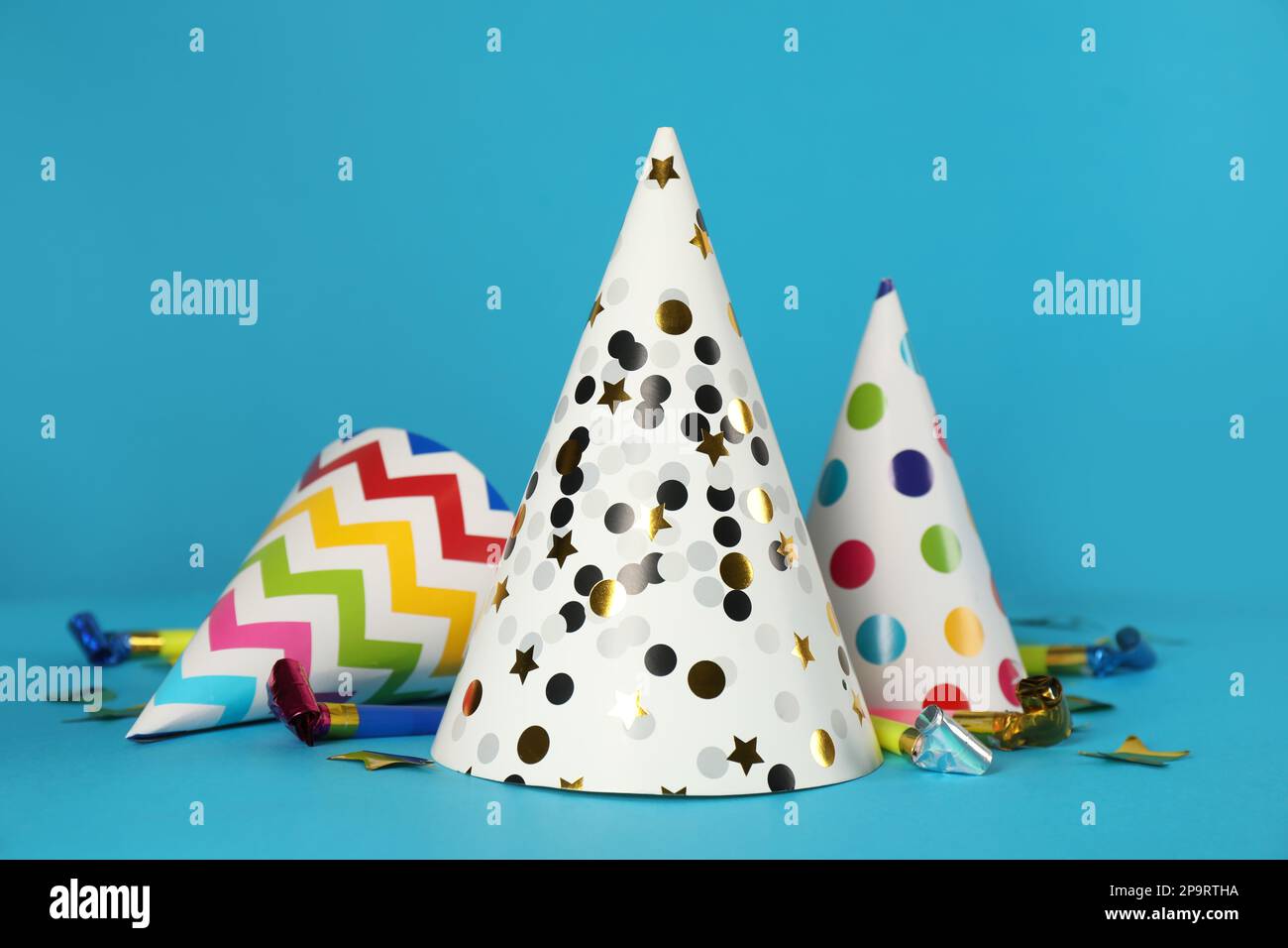 Colorful party hats and festive items on light blue background Stock ...