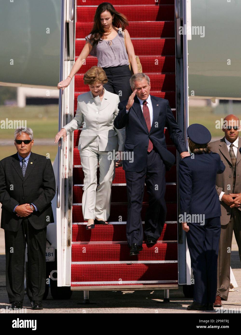 President Bush salutes as his wife first lady Laura Bush , left, and ...