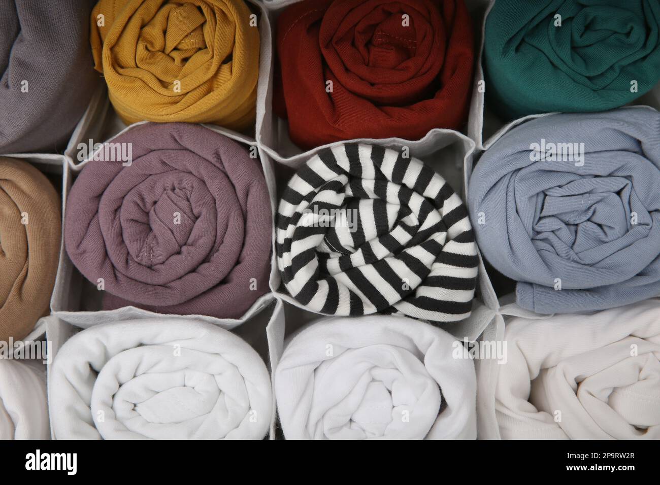 Different rolled clothes as background, top view. Vertical storage ...