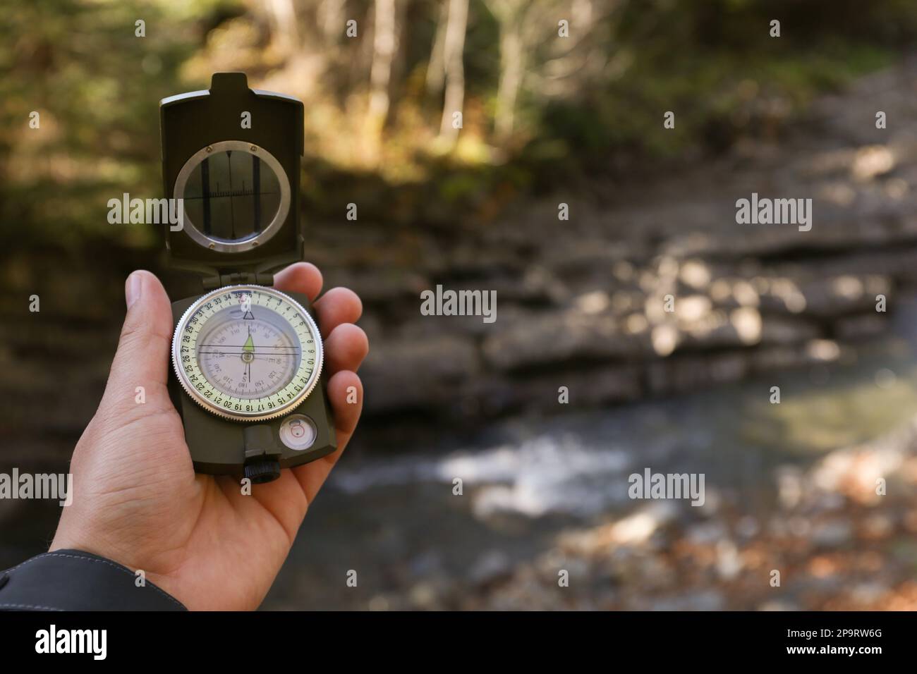 Man using compass for navigation during journey outdoors, closeup Stock ...