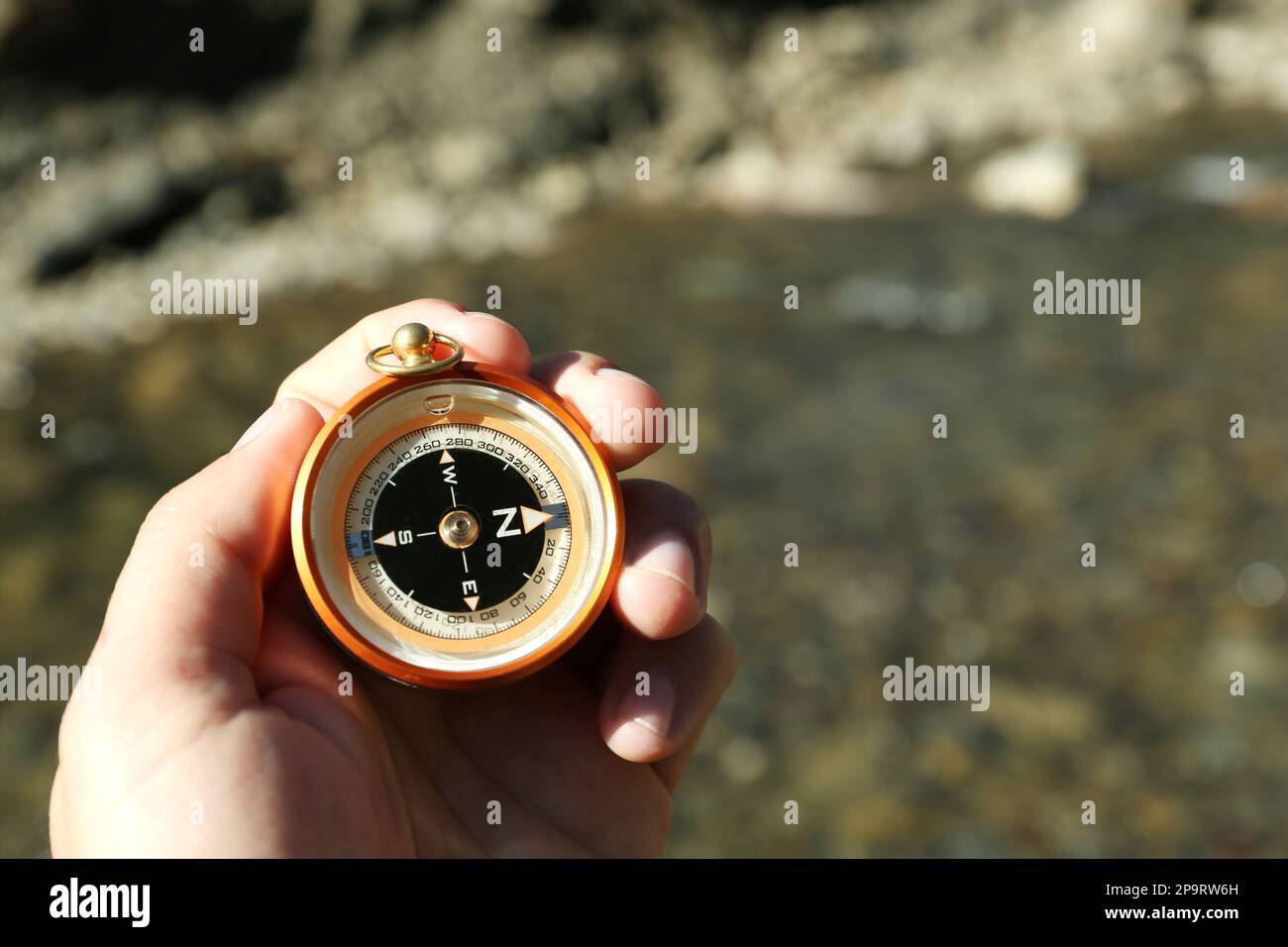 Man using compass for navigation during journey outdoors, closeup Stock ...