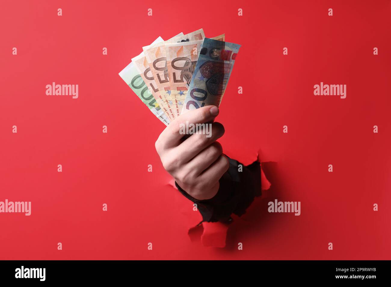 Hand breaking through paper holding hi-res stock photography and images ...