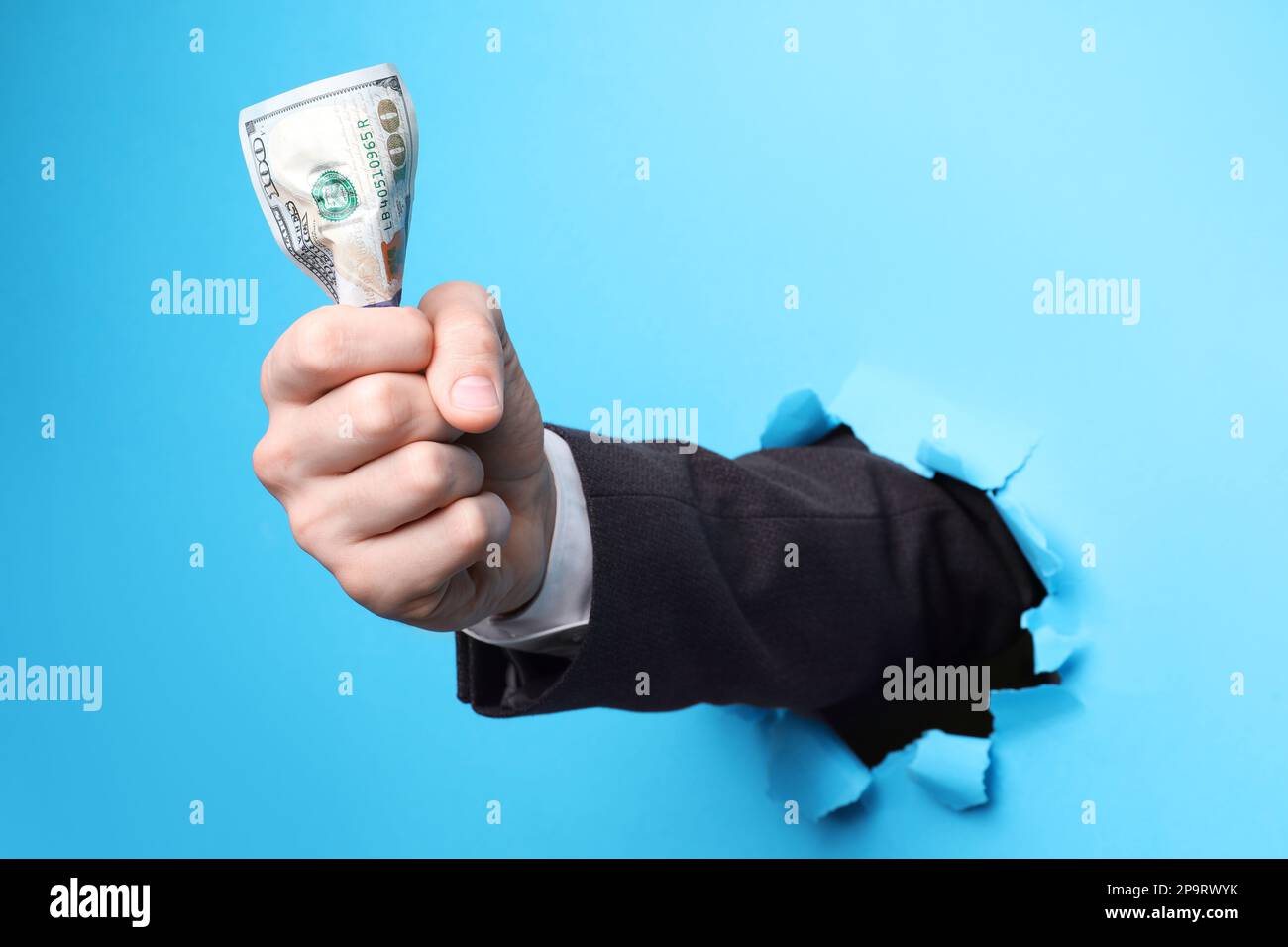 Hand breaking through paper holding hi-res stock photography and images ...