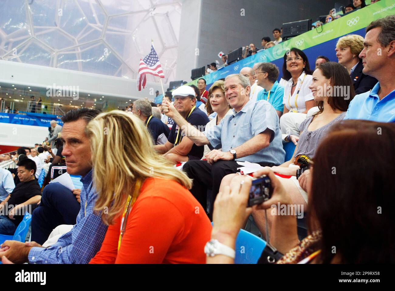 President Bush waves a flag with first lady Laura Bush and his daughter ...