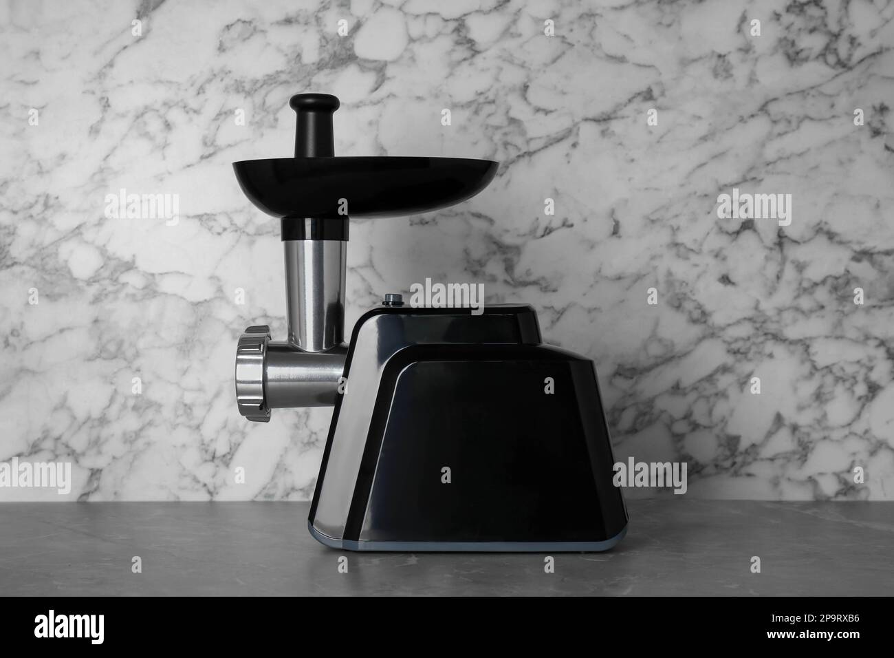 Modern electric meat grinder on grey table Stock Photo - Alamy