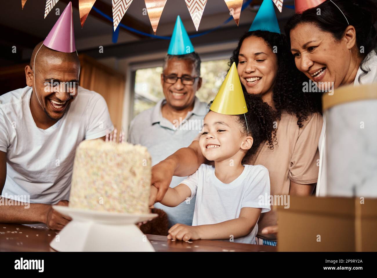 Birthday, black family and a girl cutting cake in the home during a ...