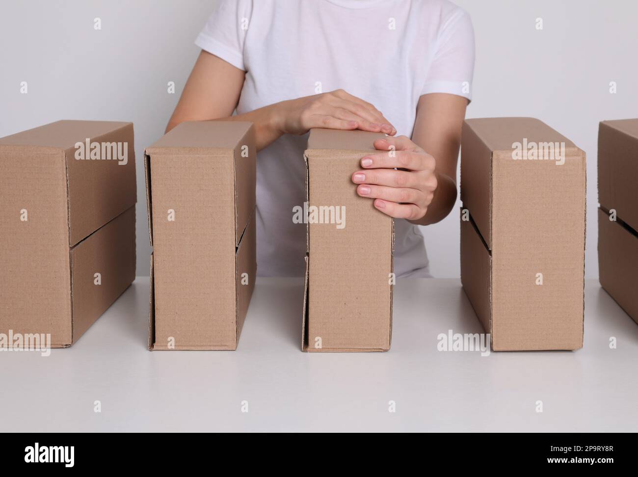 Woman folding cardboard boxes hi-res stock photography and images - Alamy