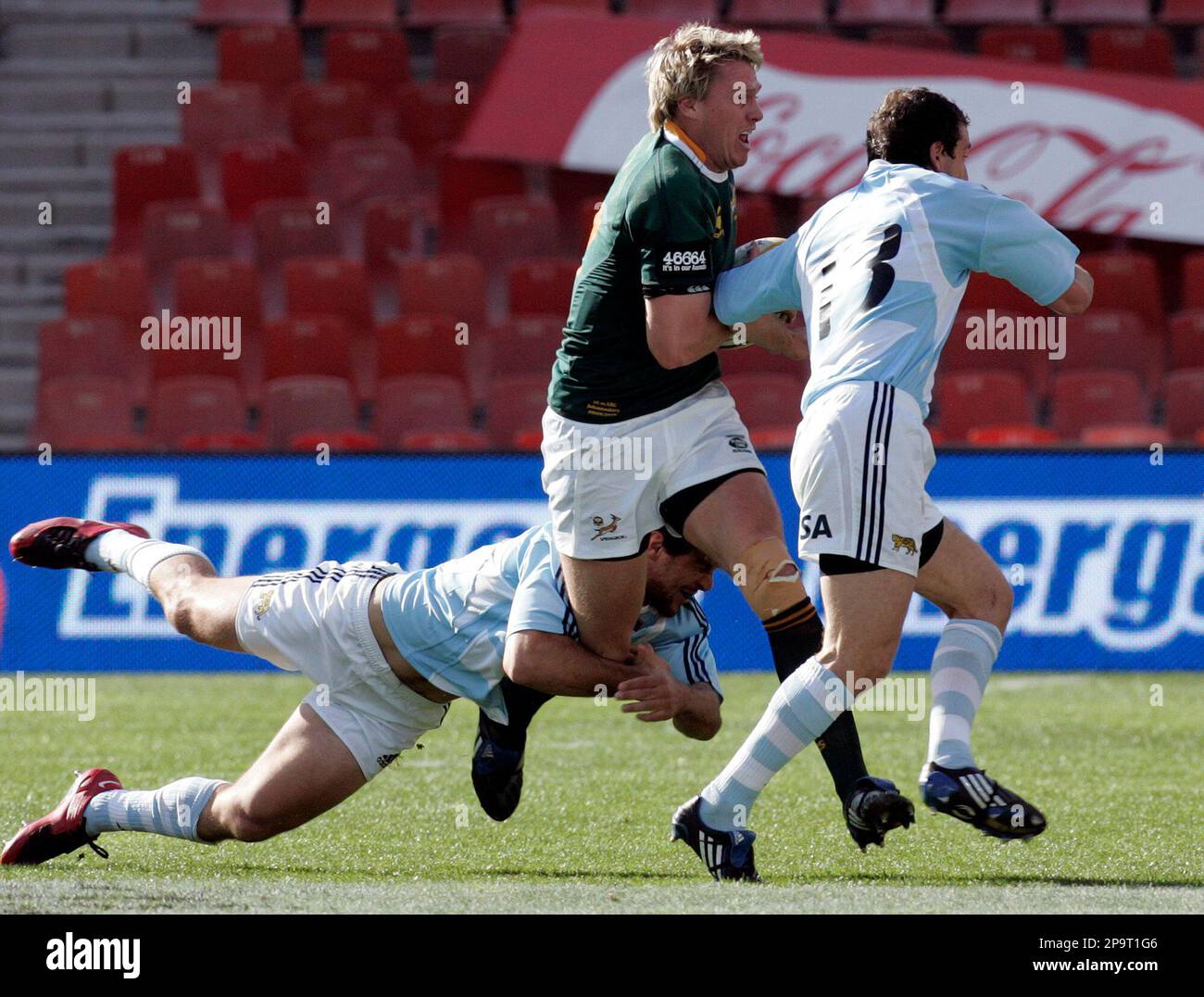 South Africa's Jean de Villiers, center, is tackled by Argentina's ...