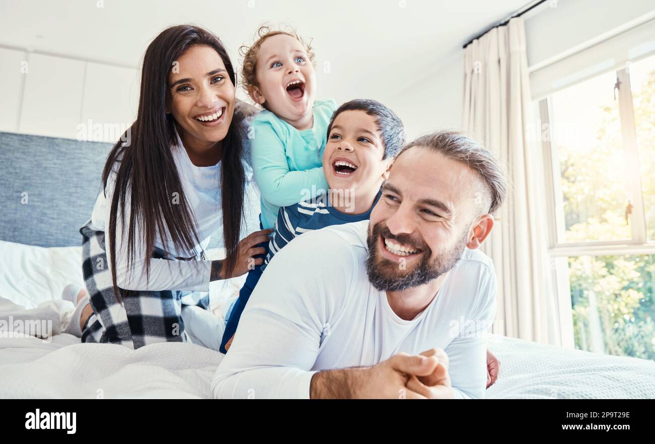 Portrait, family and laughing on bed in home, having fun and bonding ...