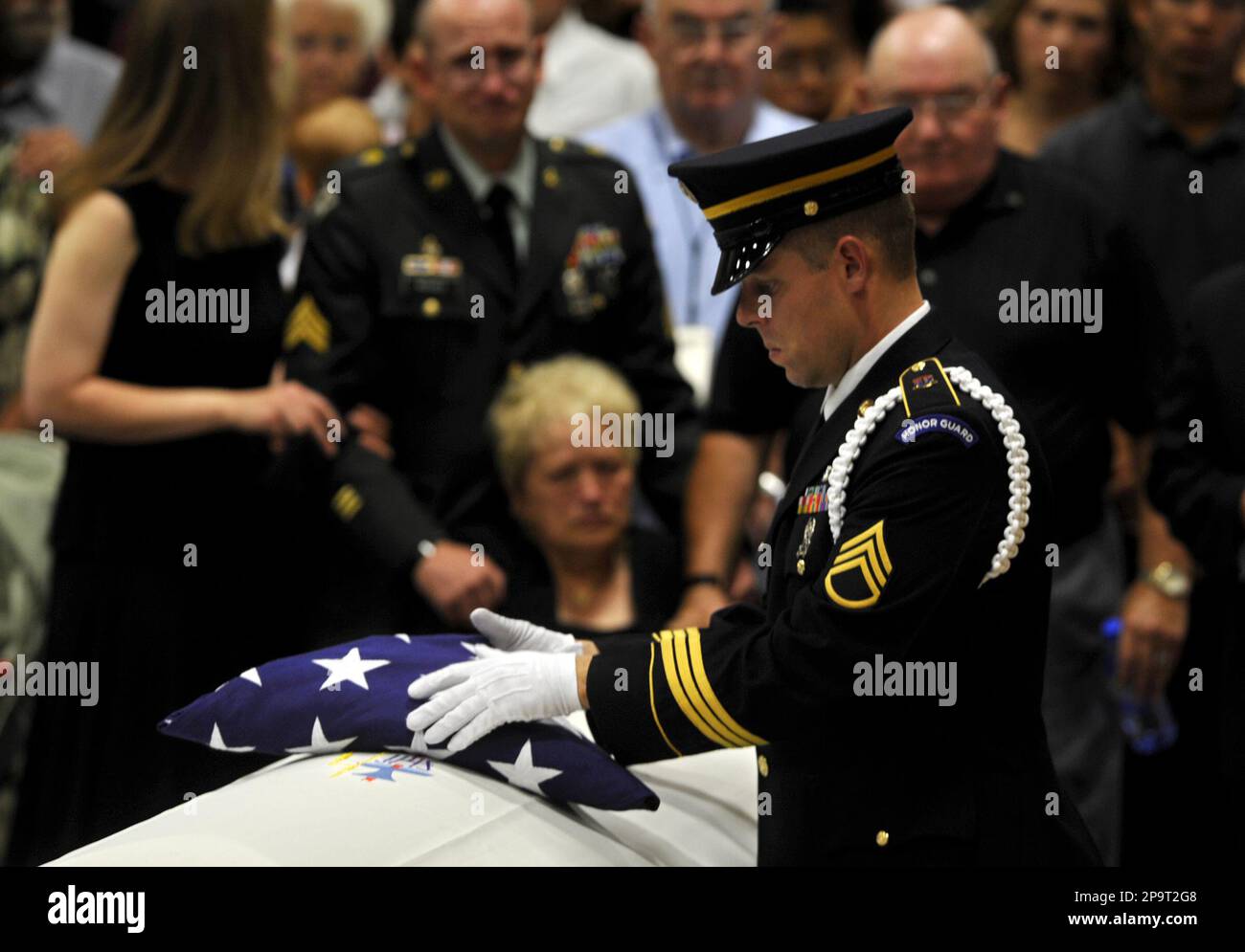 Staff Sgt. Shane Gabriel of the Honor Guard places a folded flag atop ...
