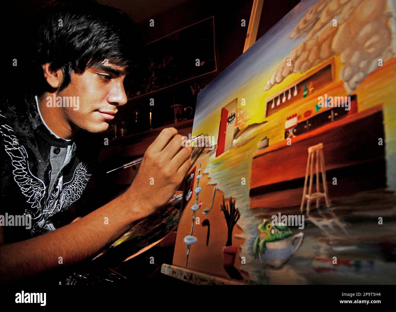 Daniel Leon, a 17-year old artist works on a painting in his home ...