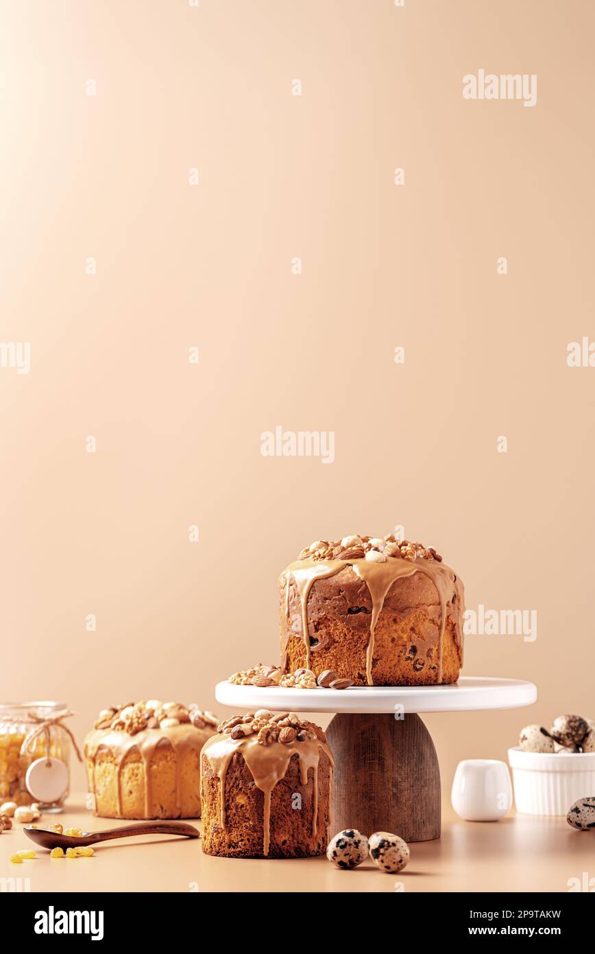 Caramel glazed Easter cakes decorated with nuts on pastel background ...