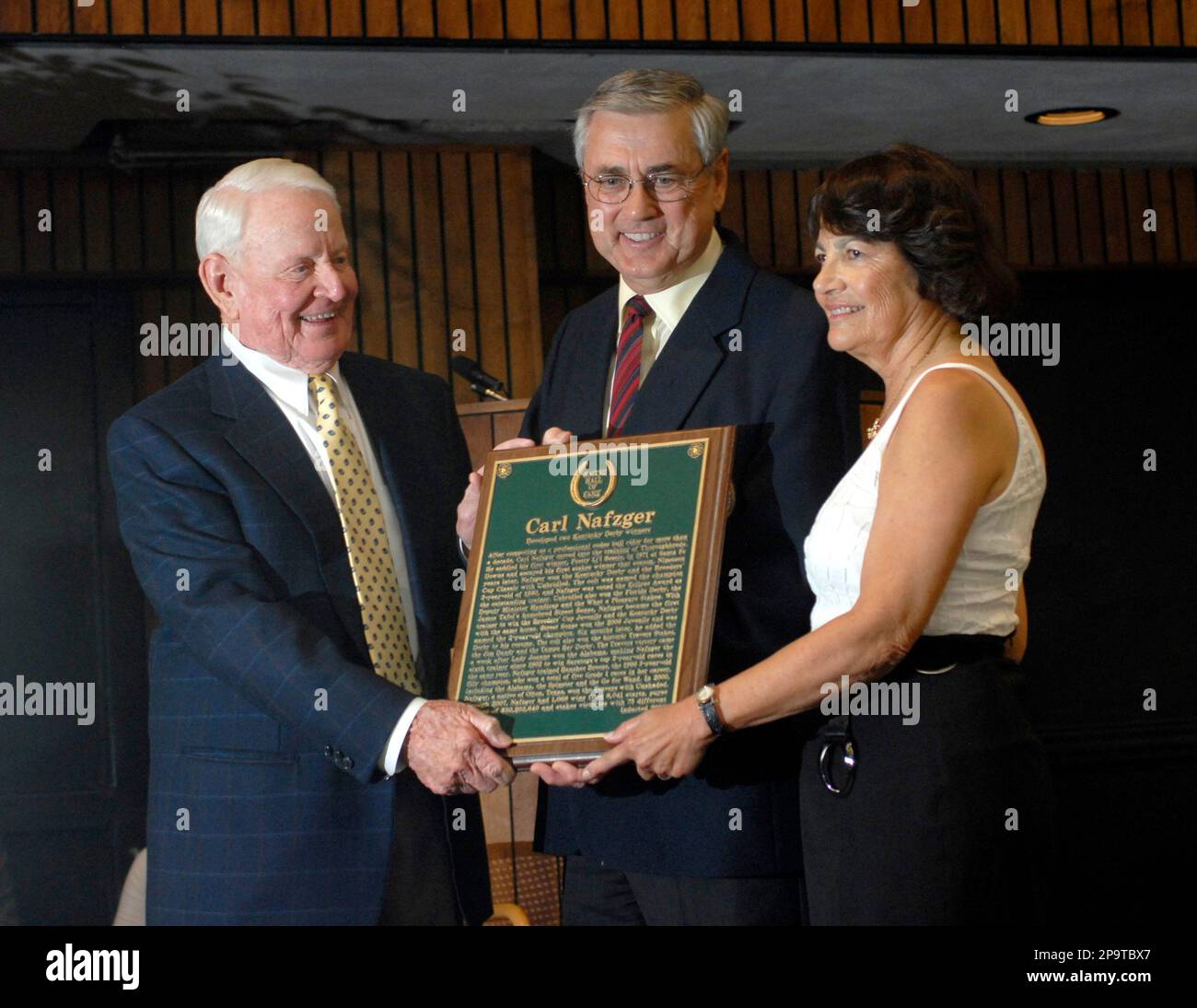 Trainer Carl Nafzger, center, receives a hall of fame plaque from James ...