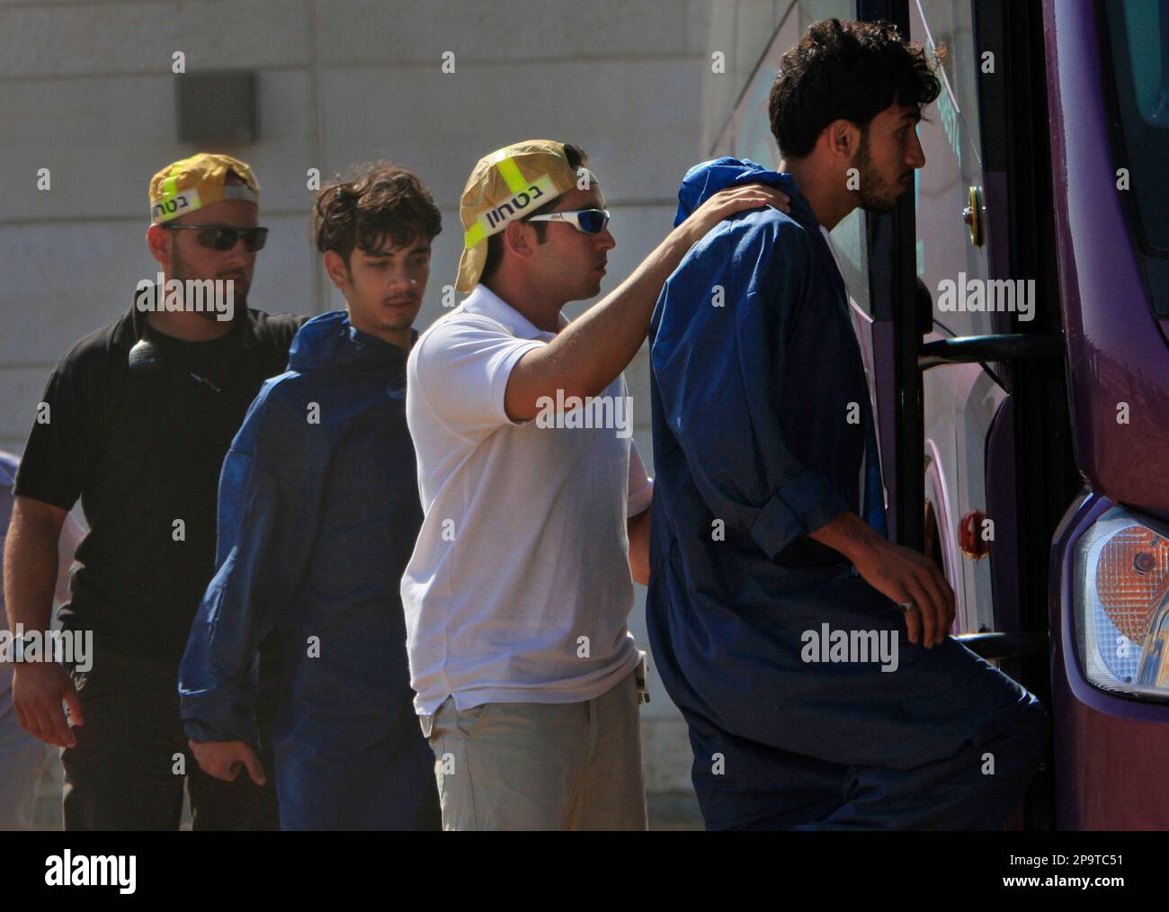 Israeli security officers escort Palestinians, part of a small group of ...