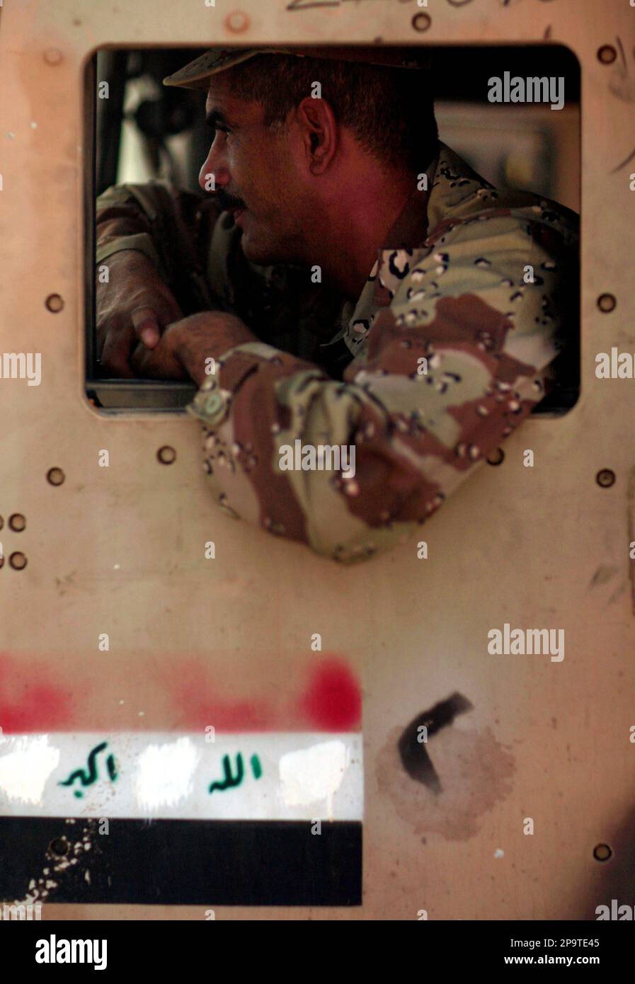 A soldier from the 1st Iraqi Army Division is seen through a humvee ...