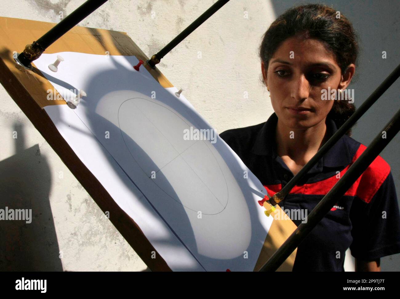 A Pakistani scientist looks at an image of the solar eclipse seen in ...