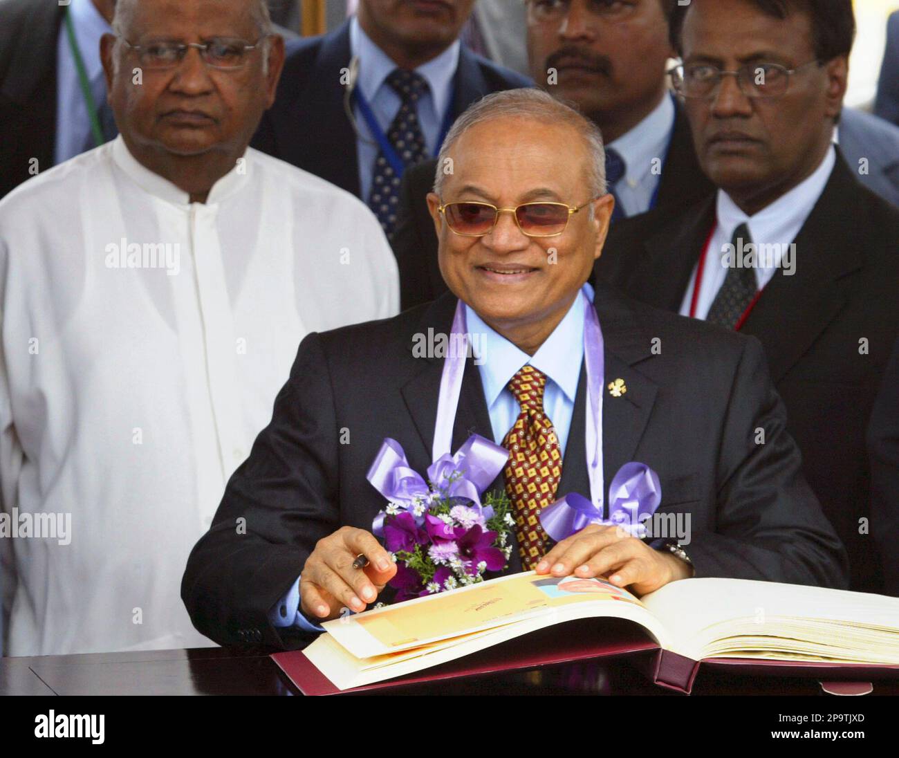 Maldivian President Maumoon Abdul Gayoom, front, signs a visitor's book ...