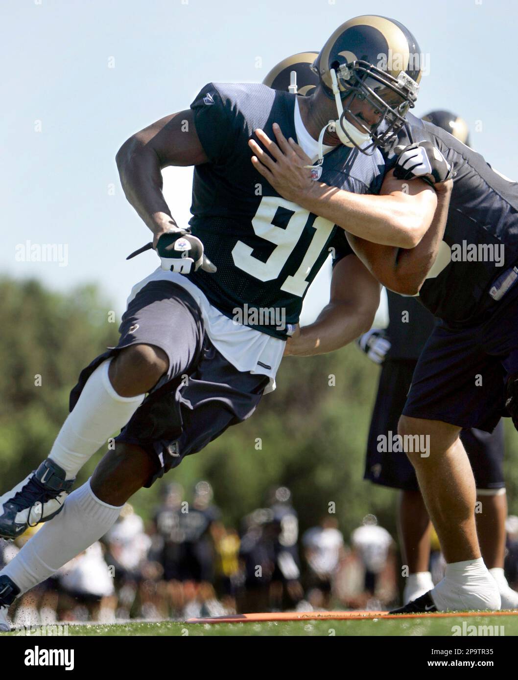 St. Louis Rams' Leonard Little, left, powers his way around teammate C ...