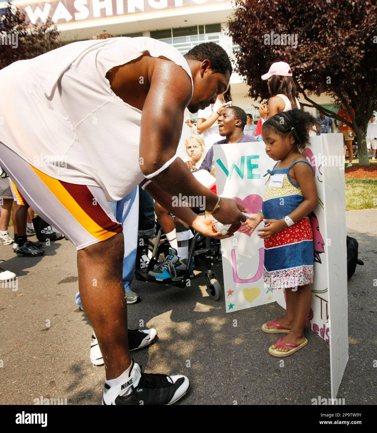 Washington Redskins' linebacker Marcus Washington signs a football for ...