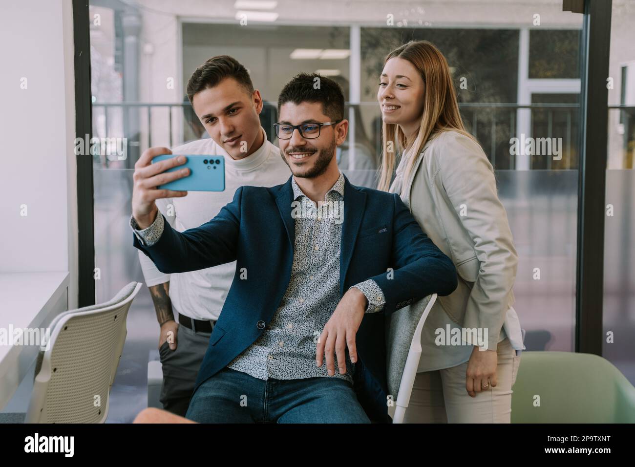 Three young and attractive work friends taking a selfie together on ...