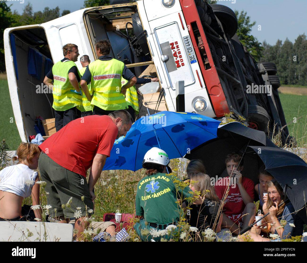 Rescue personnel aid victims who shelter from the sun under umbrellas ...
