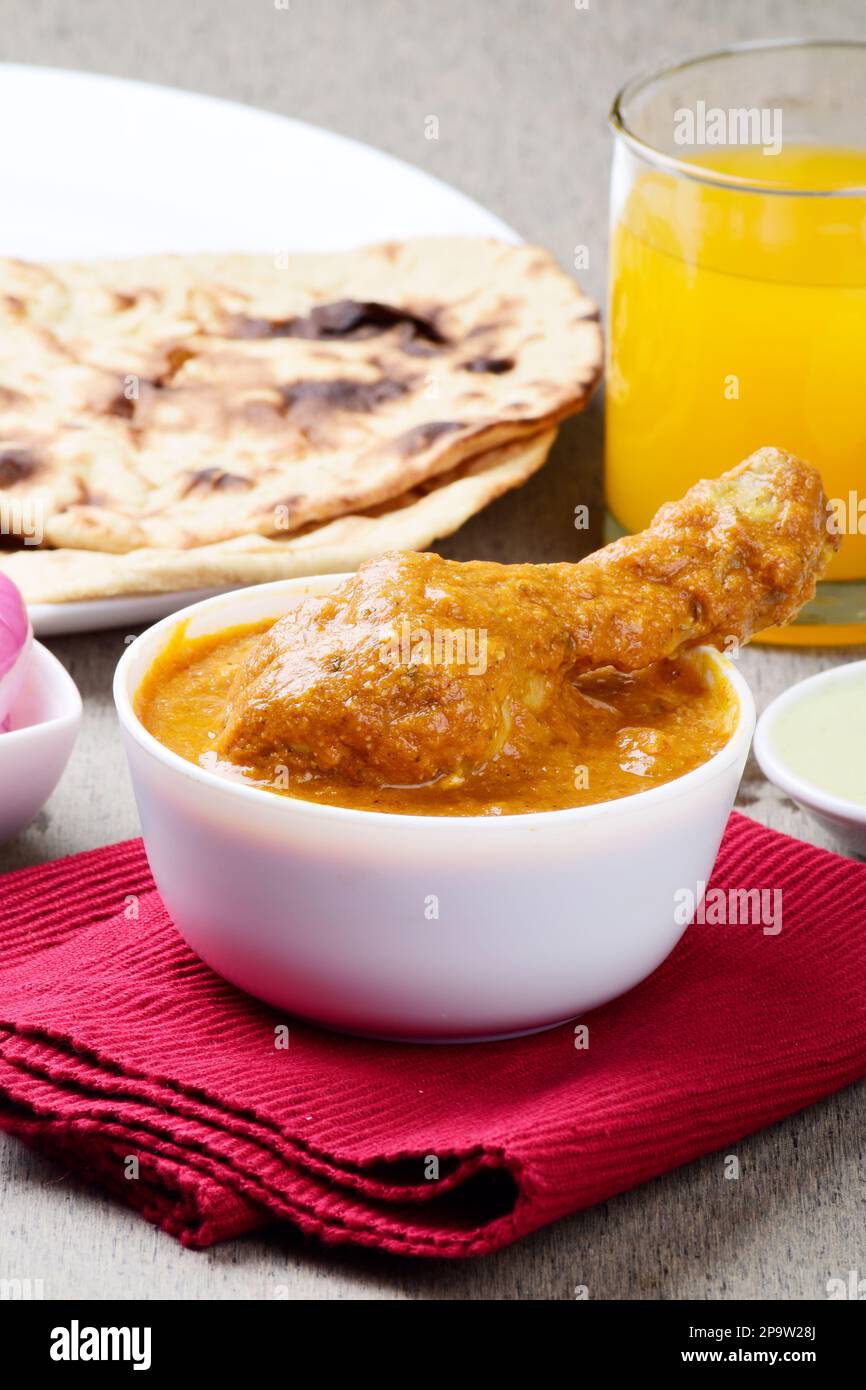 Closeup of butter chicken in bowl with roti and cold drink, punjabi ...