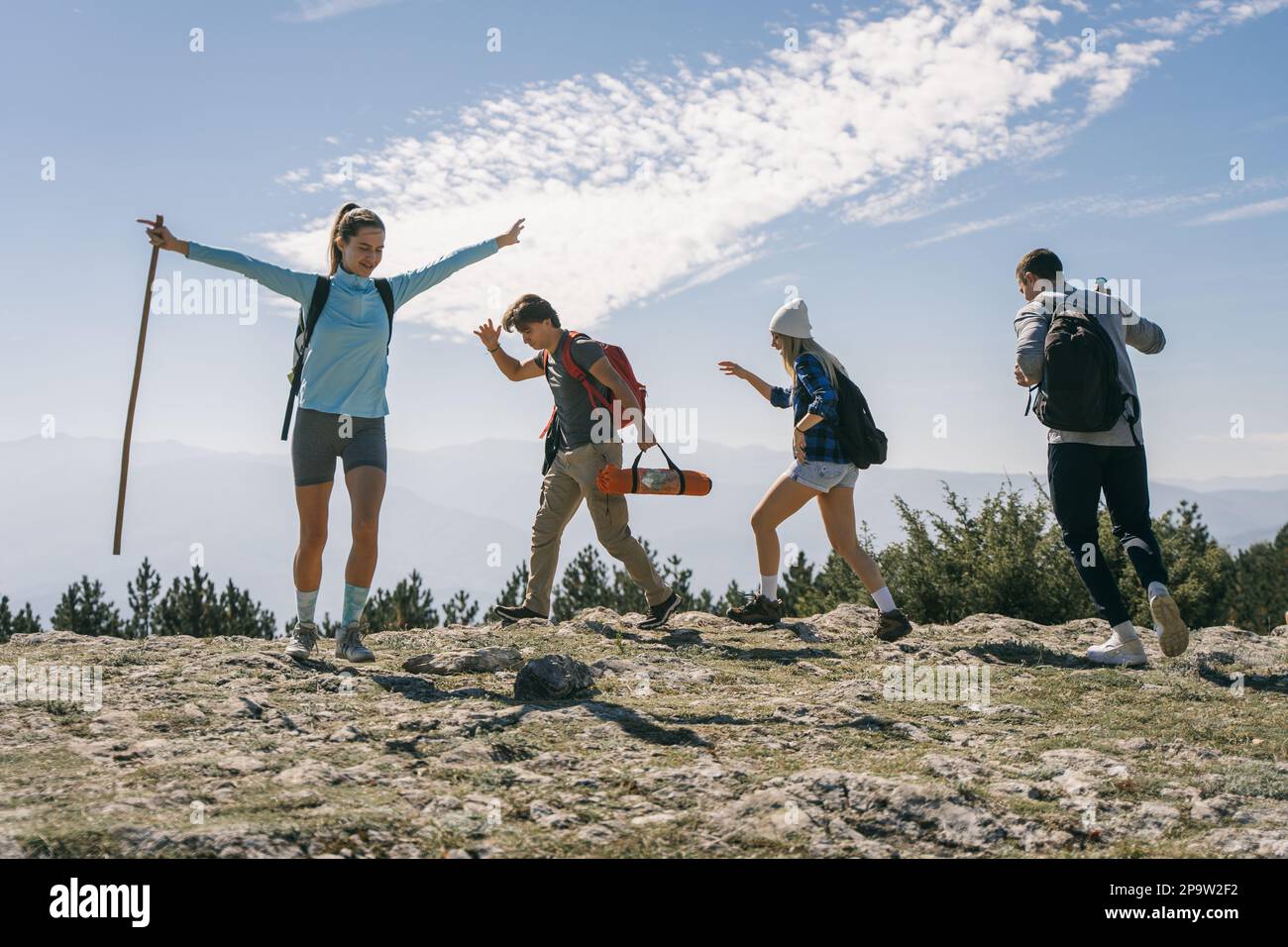Group of four hikers walking at the top of the mountain Stock Photo - Alamy