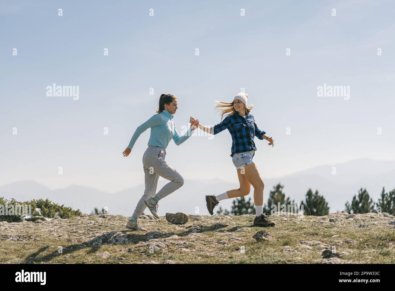 Two amazing girls running at the top of the mountain Stock Photo - Alamy