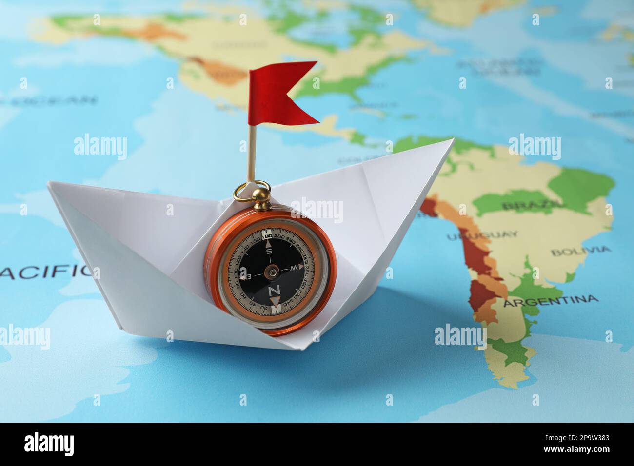 White paper boat with compass on world map Stock Photo - Alamy