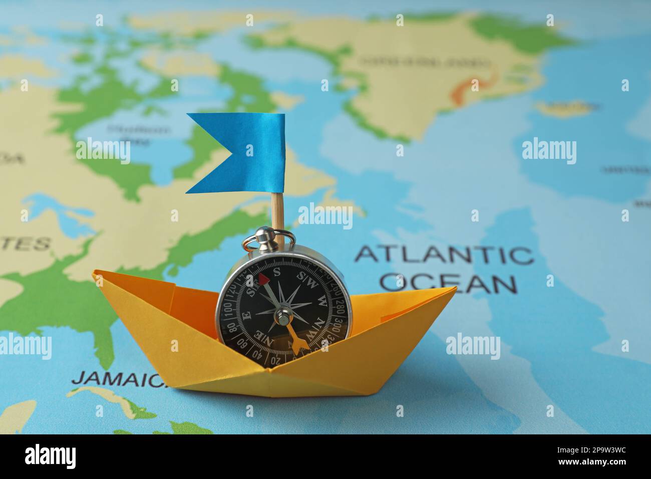 Yellow paper boat with compass on world map Stock Photo - Alamy