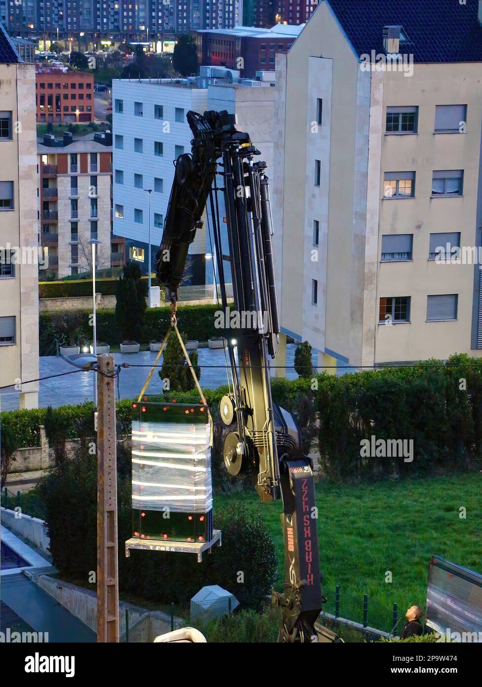 Glass panels being delivered to the flat roof of a block of flats by a ...
