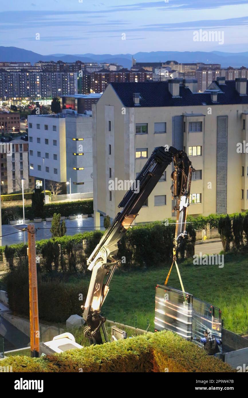 Glass panels being delivered to the flat roof of a block of flats by a ...