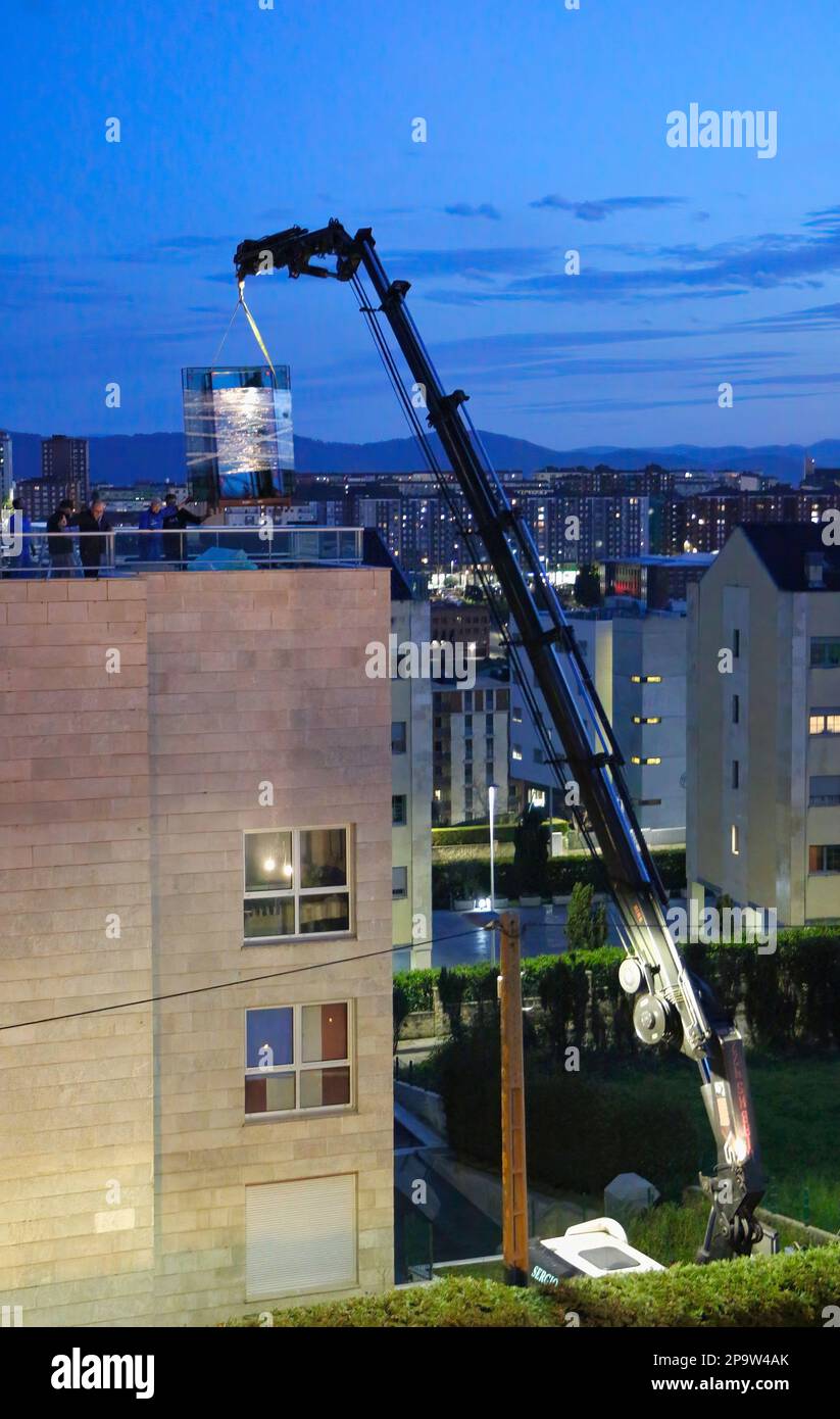 Glass panels being delivered to the flat roof of a block of flats by a ...