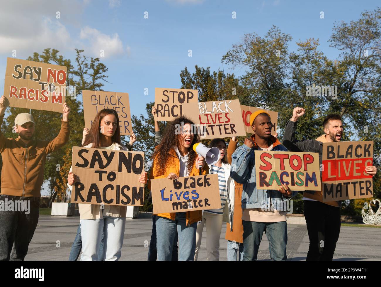 Protesters demonstrating different anti racism slogans outdoors. People ...