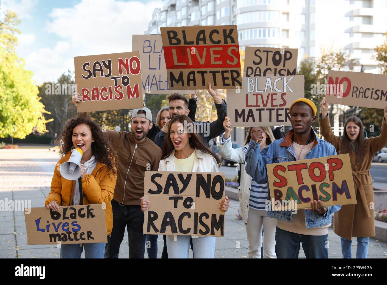 Protesters demonstrating different anti racism slogans outdoors. People ...