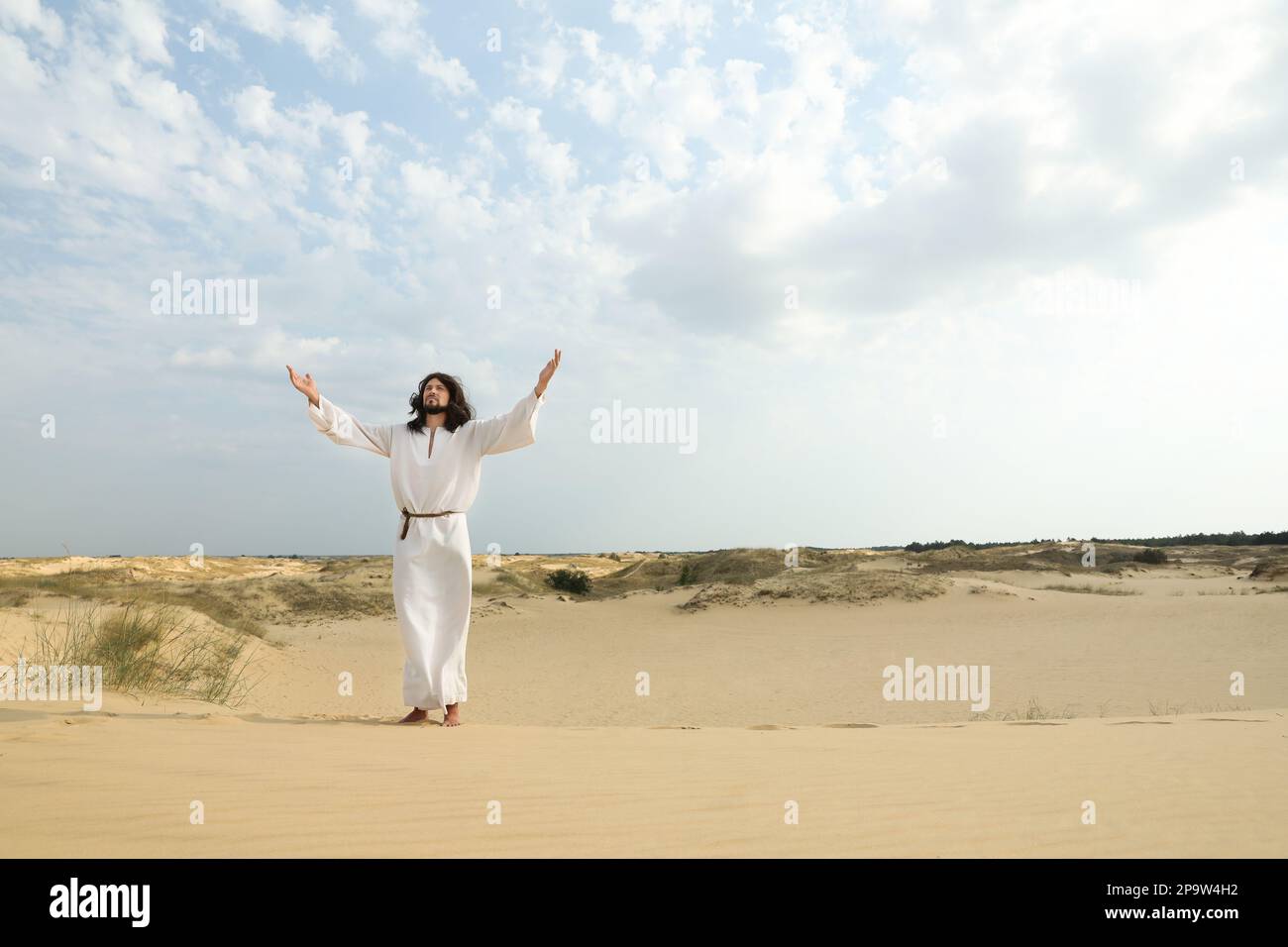 Jesus Christ raising hands in desert. Space for text Stock Photo - Alamy