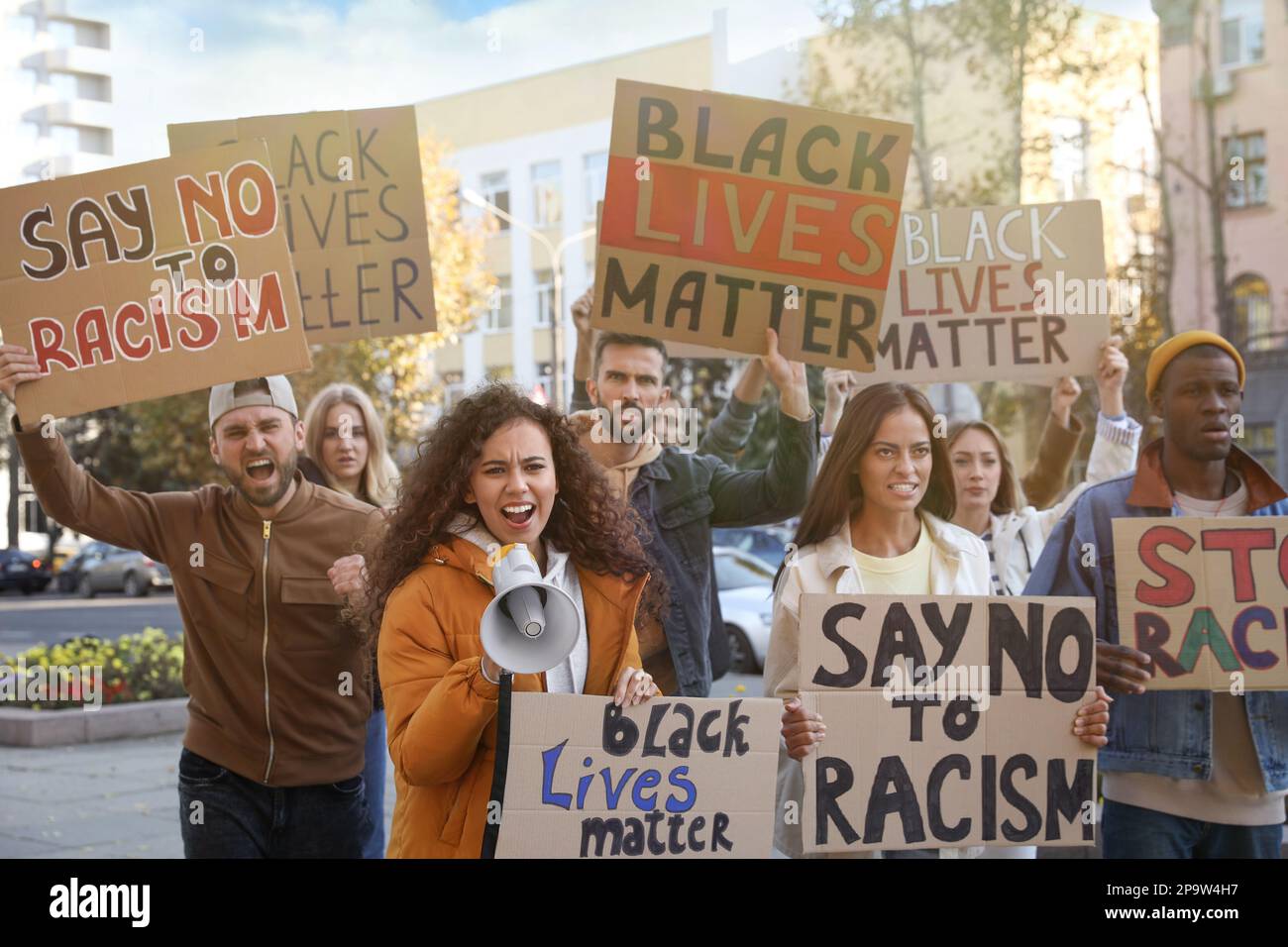 Protesters demonstrating different anti racism slogans outdoors. People ...