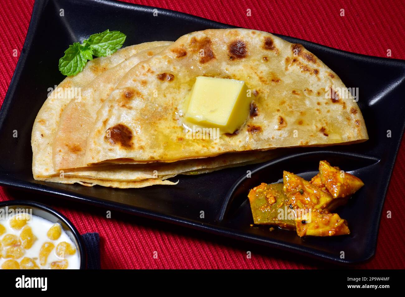 Stuffed Pratha with butter and pickle in plate, healthy indian ...