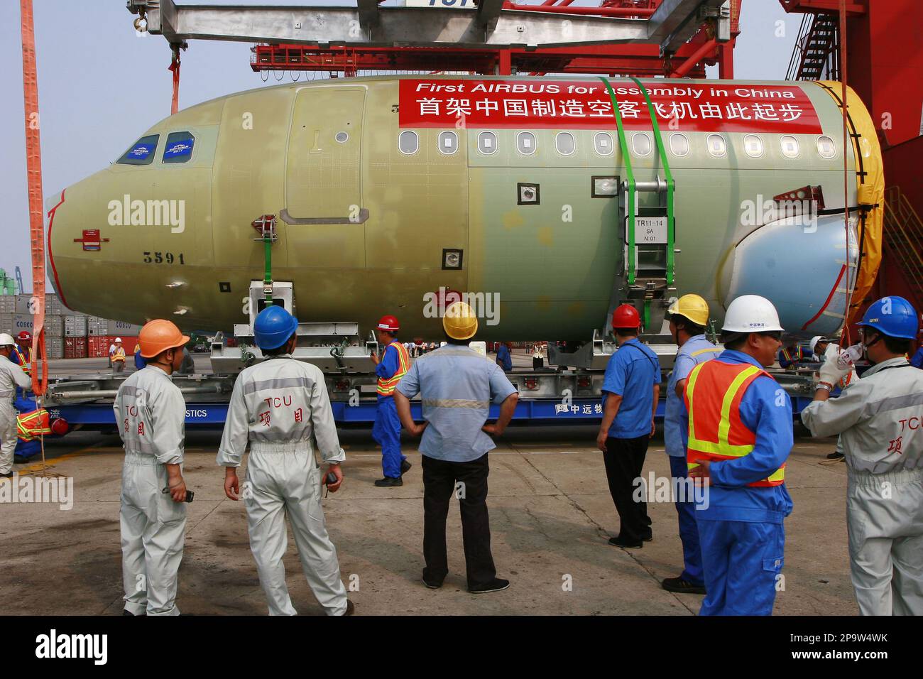 Chinese workers look at the fuselage of an Airbus A320 on its arrival ...