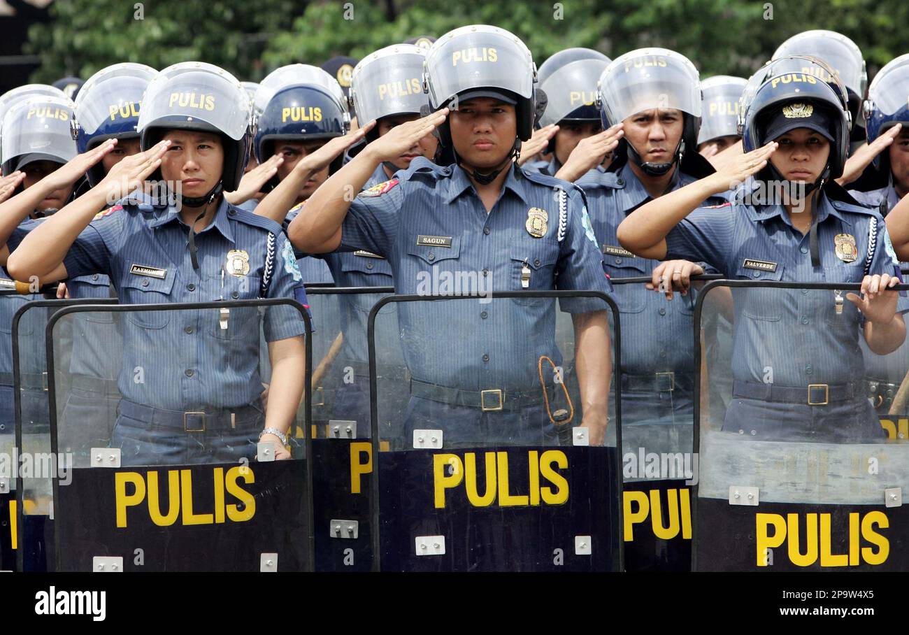 Philippine National Police officers salute as they gather for a "human ...
