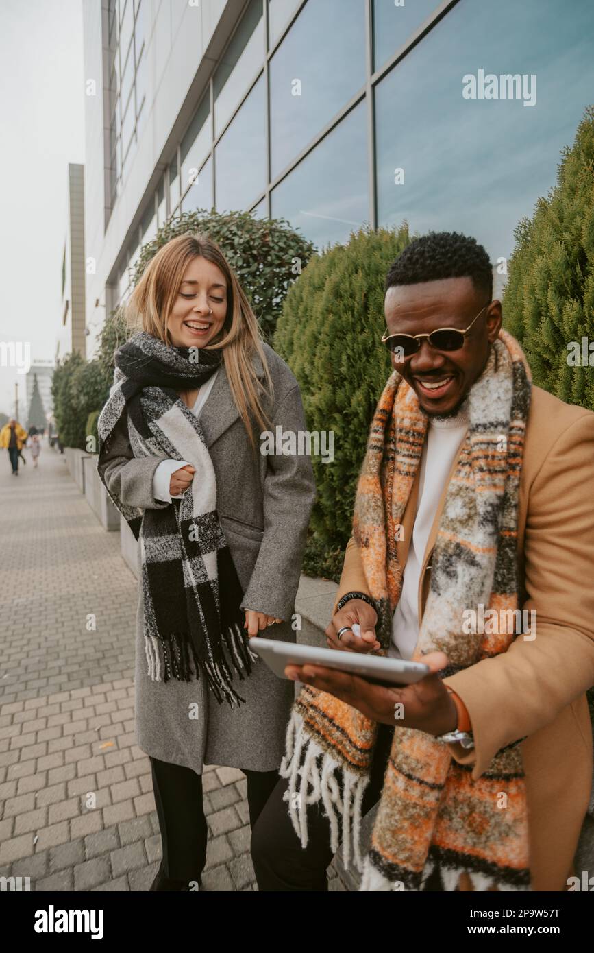 Two business colleagues smiling and working infront of the building ...