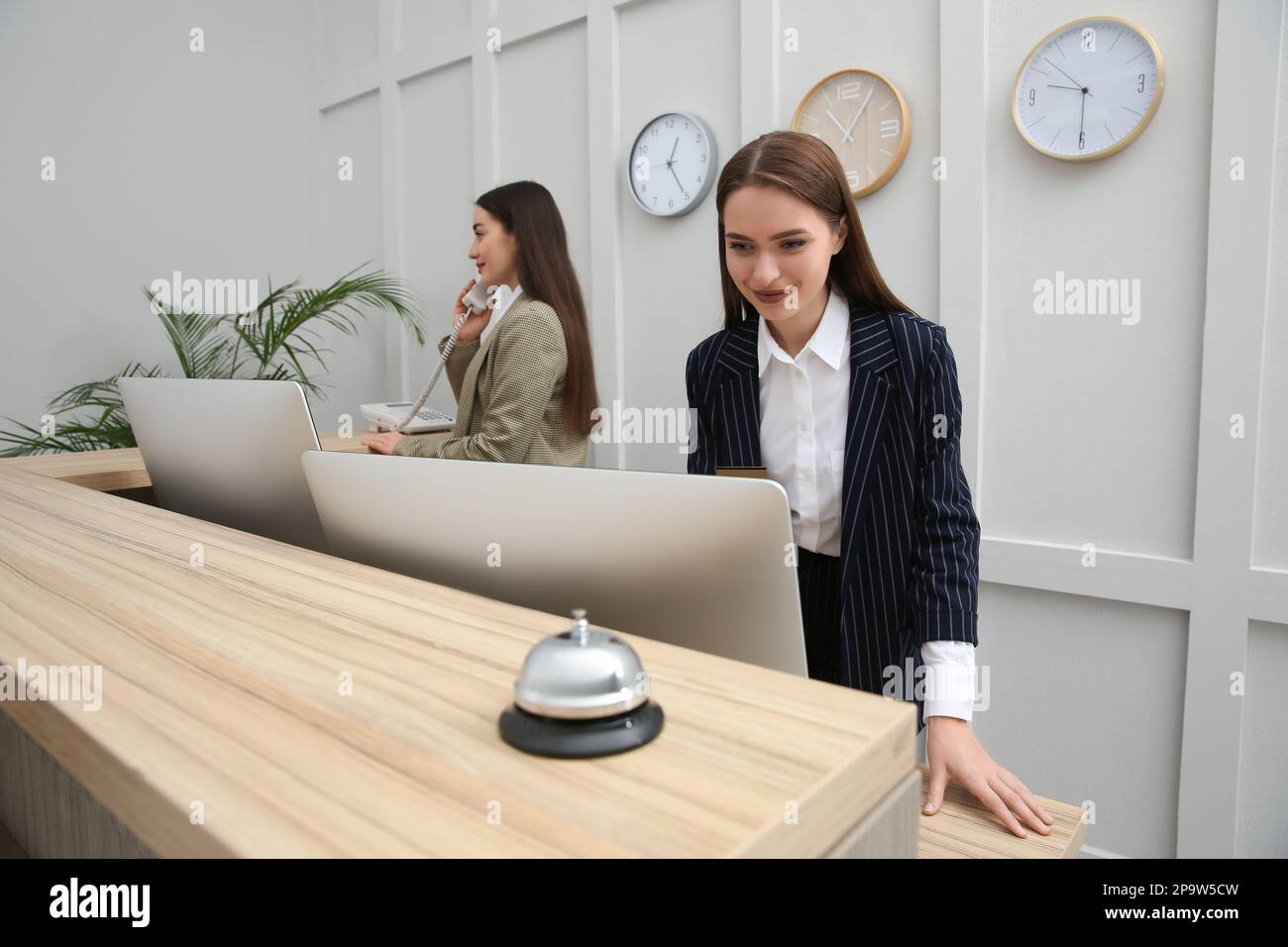 Beautiful receptionists working at counter in hotel Stock Photo - Alamy