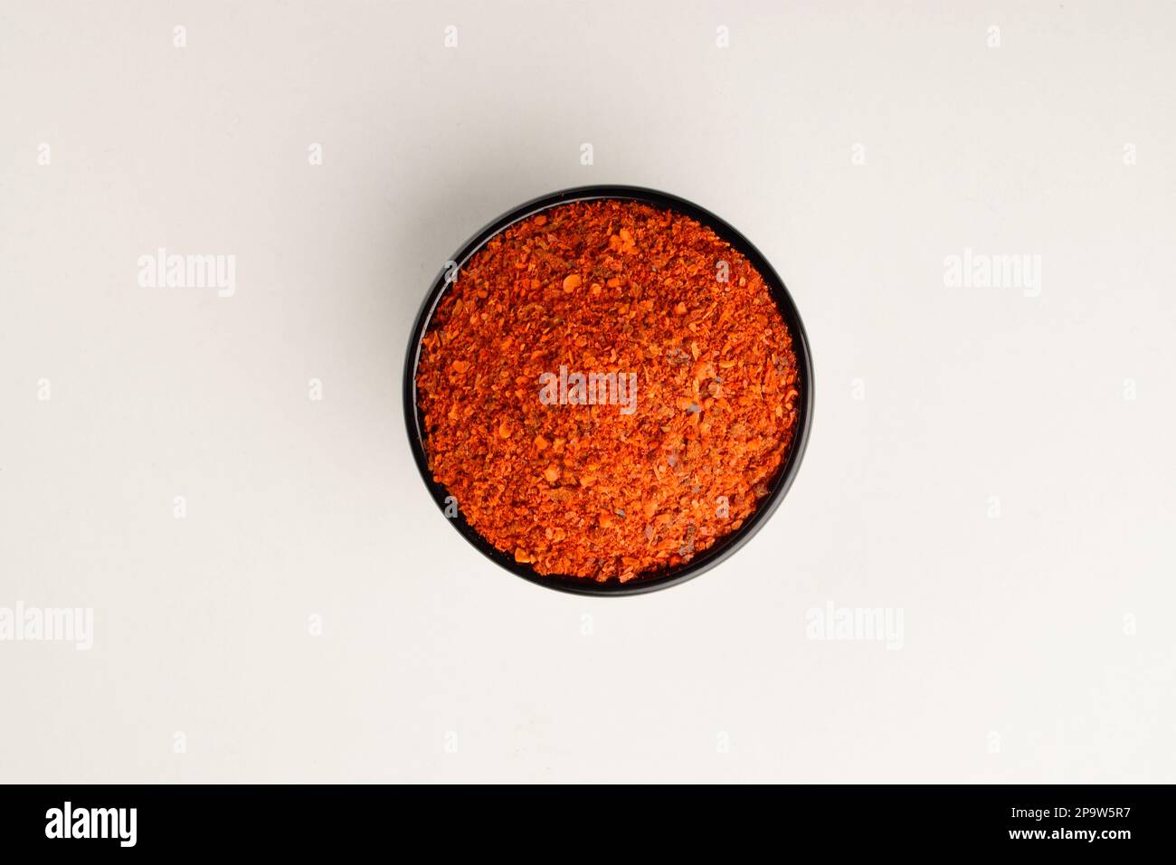 Top view of ground red chilli on white background, spicy ingredients ...