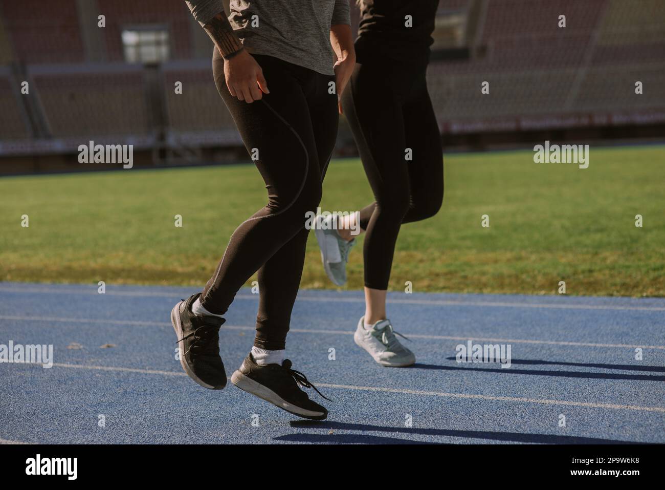 A sports couple is jogging slowly on the sports track, at the stadium ...