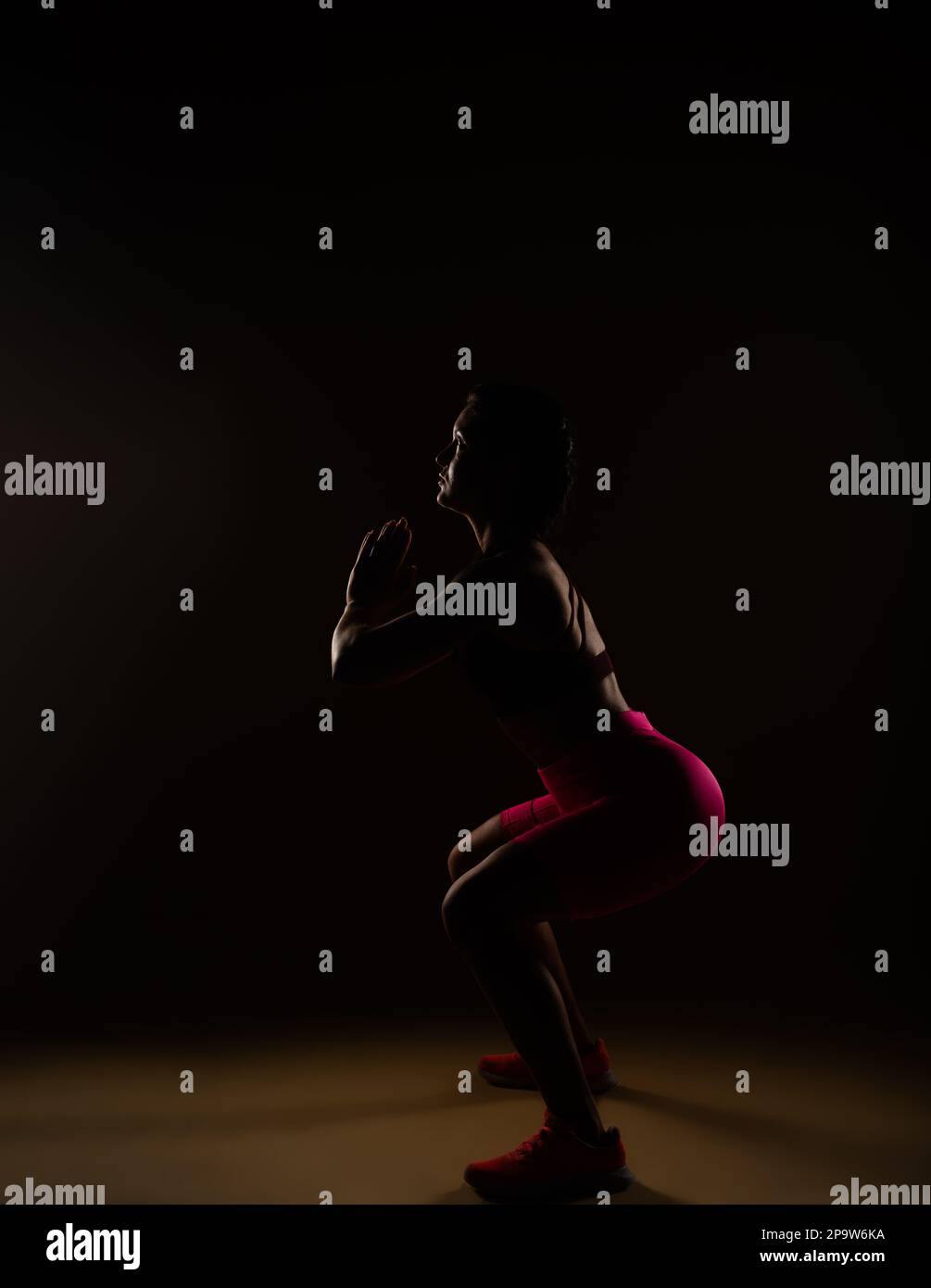 A side view photo of strong fit woman doing squats. Silhouette Stock ...