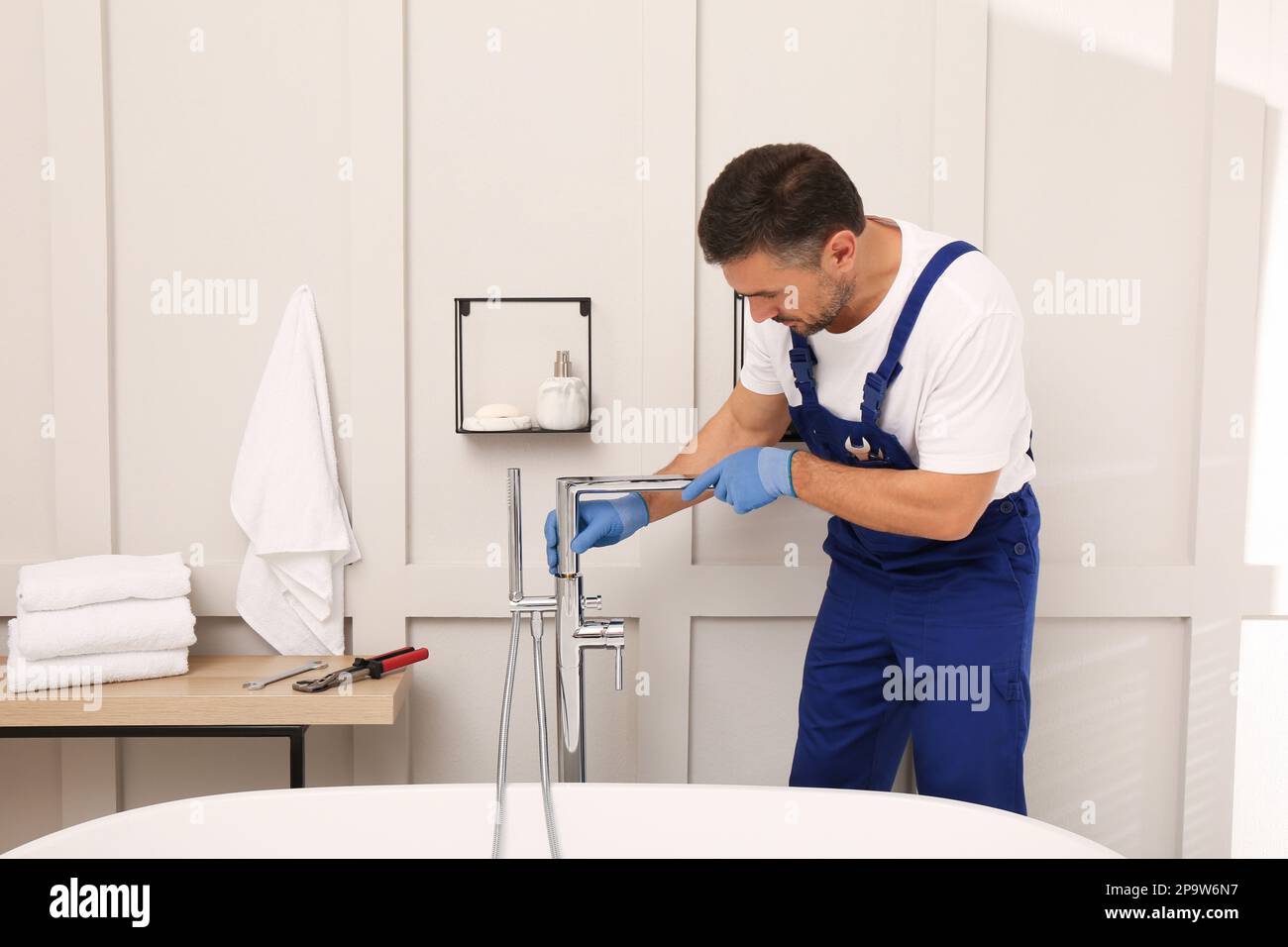 Professional plumber installing water tap in bathroom Stock Photo - Alamy