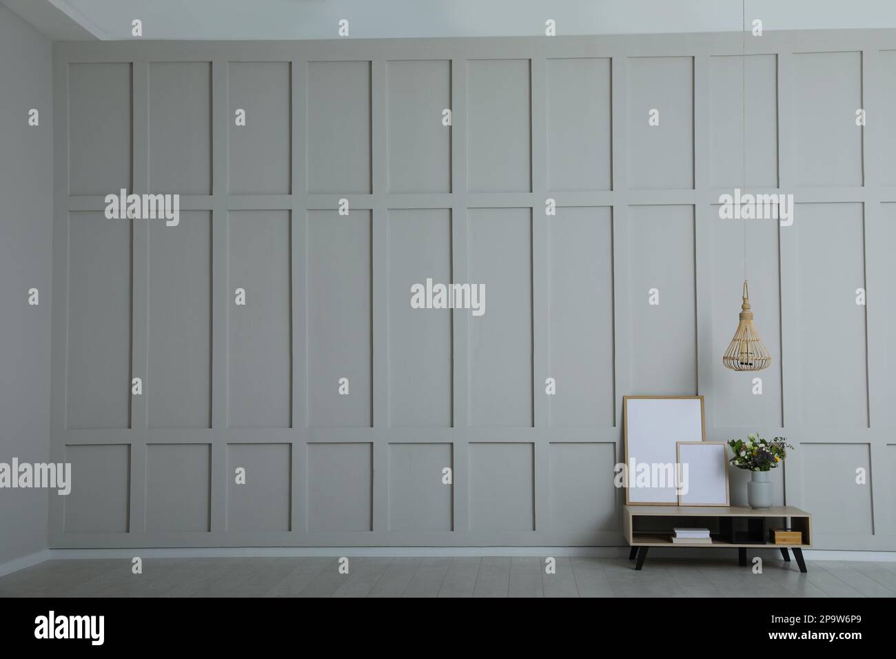 Simple room interior with console table, decor elements and empty wall ...