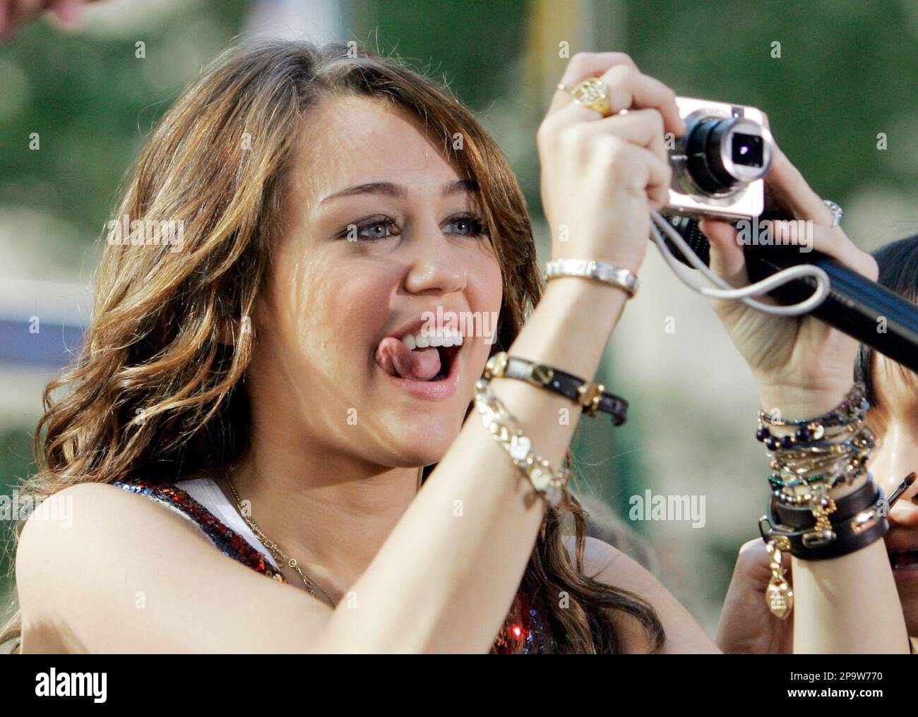 Actress and singer Miley Cyrus takes a photo of the crowd between songs ...