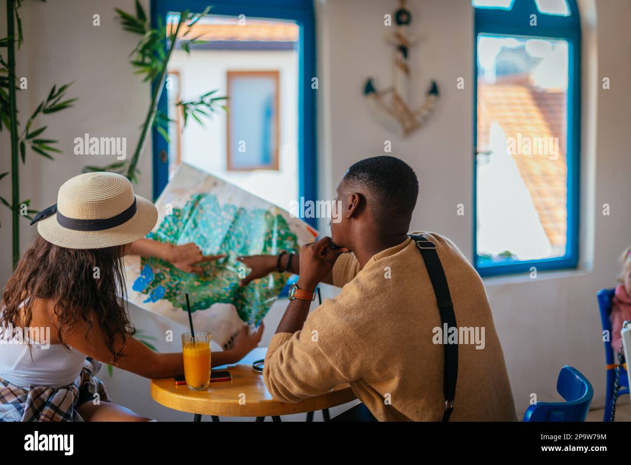 A black male tourist is helping his female white friend with the ...